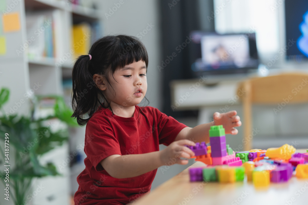 Asian cute funny preschooler little girl in a colorful shirt playing ...