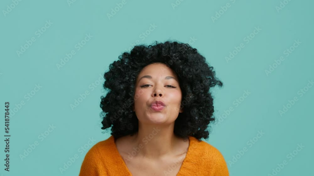 Smiling adorable curly woman with cute afro hairstyle in orange outfit ...