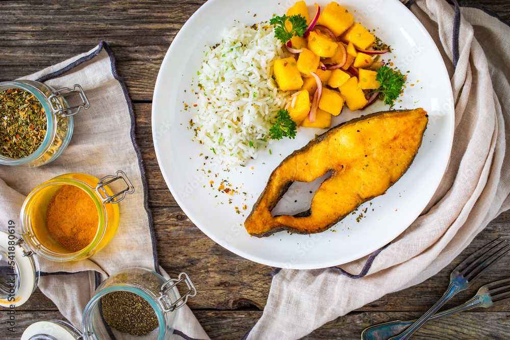 Fish dish - fried halibut with white boiled rice and avocado on wooden ...