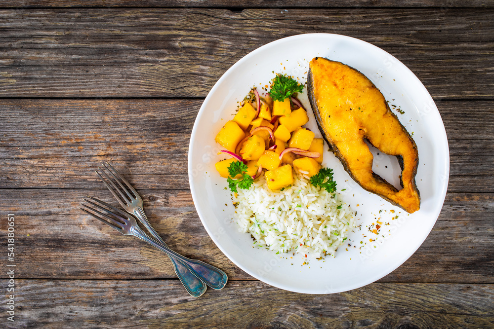 Fish dish - fried halibut with white boiled rice and avocado on wooden ...