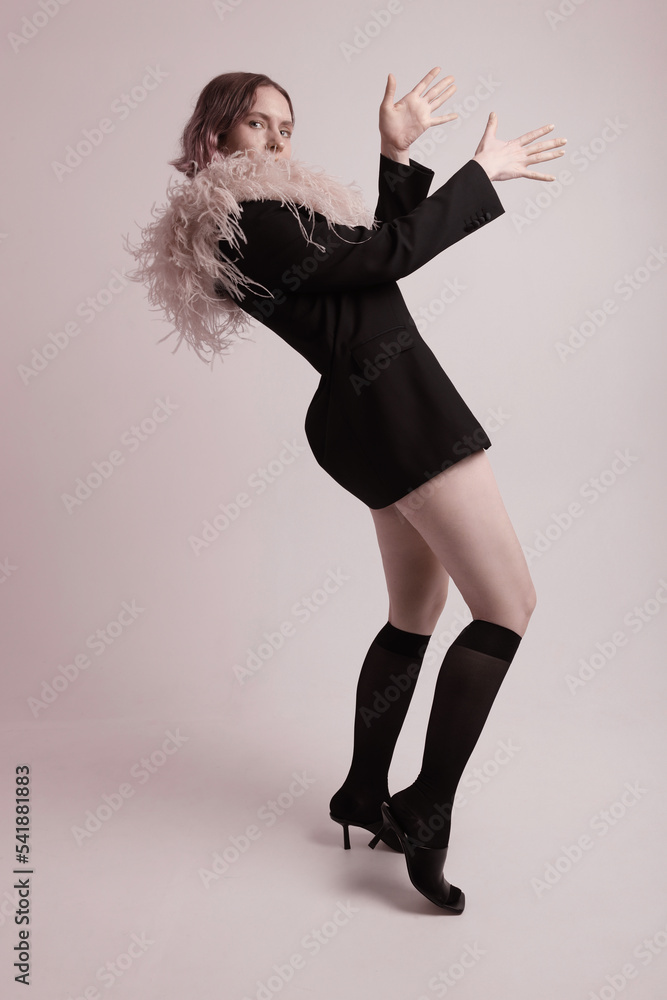 Studio portrait of stylish woman posing over white wall. Vertical mock ...