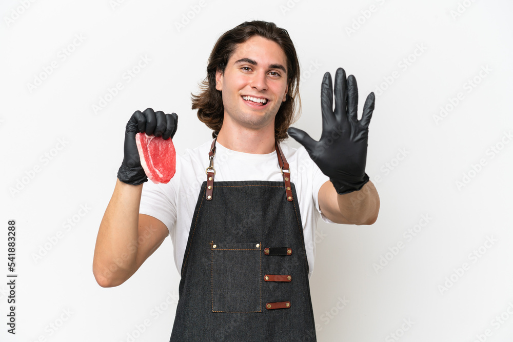Butcher handsome man wearing an apron and serving fresh cut meat ...