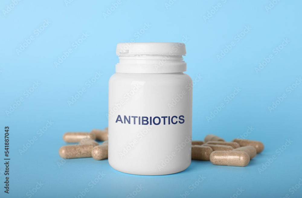 Plastic bottle with antibiotic pills on light blue background Stock ...