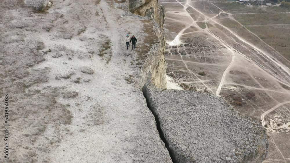 Romantic tourist couple people holding hands on cliff edge view from ...