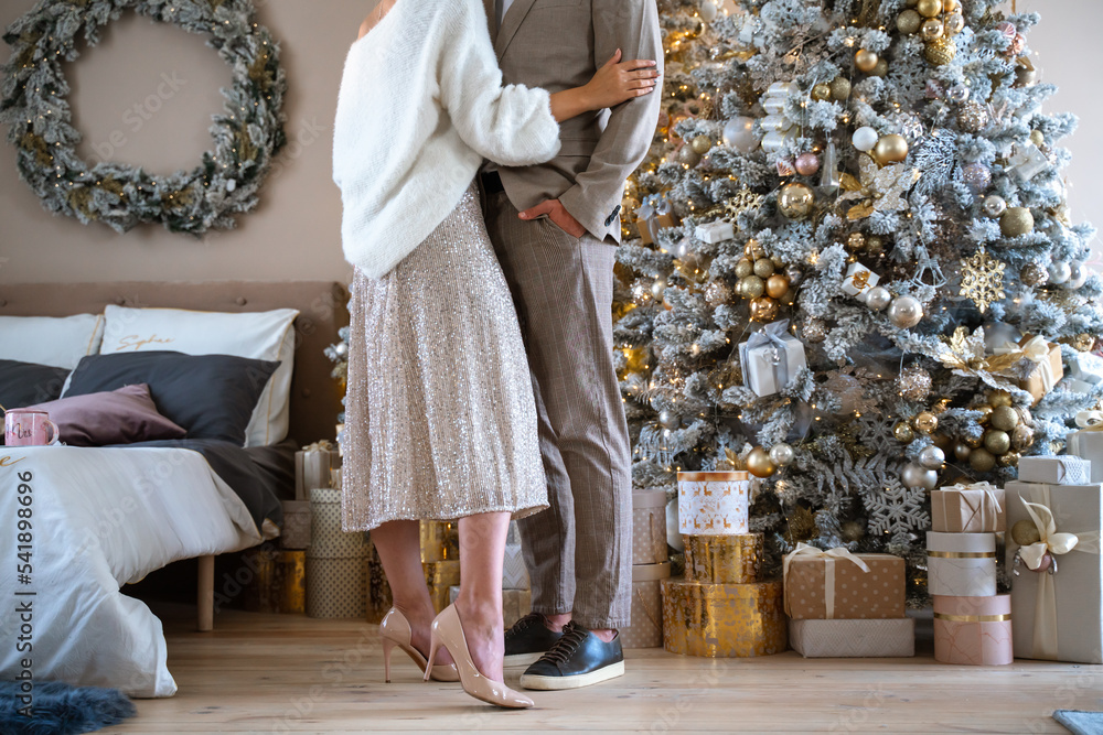 Romantic couple standing near Christmas tree at home and hugging Stock ...