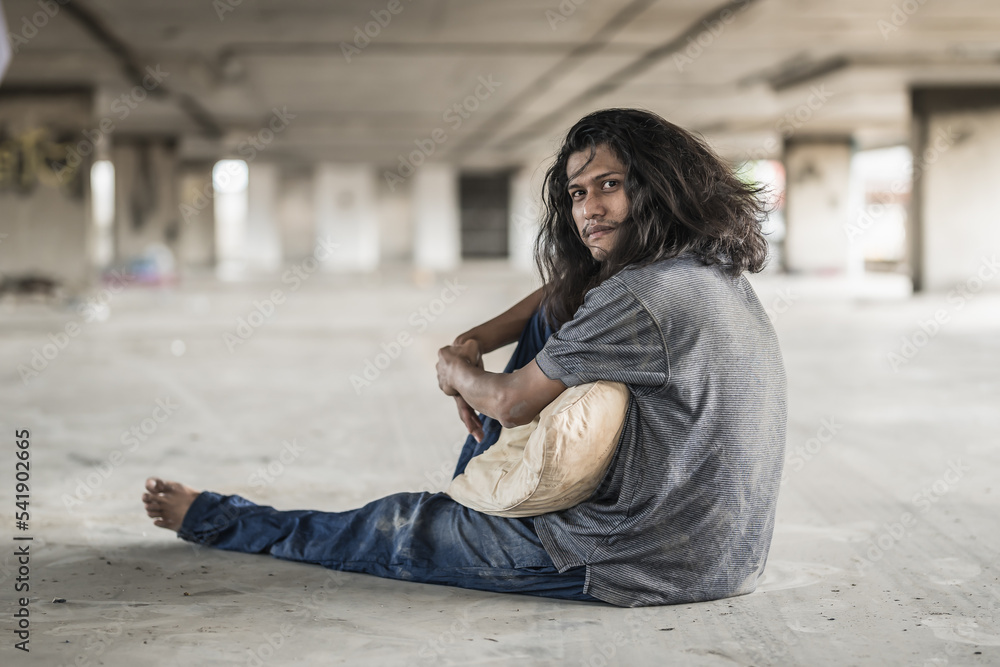 Homeless people sit on the streets in the shadows of buildings and ask ...