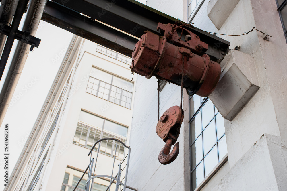old factory exterior with large metal beam and electric rail cable ...