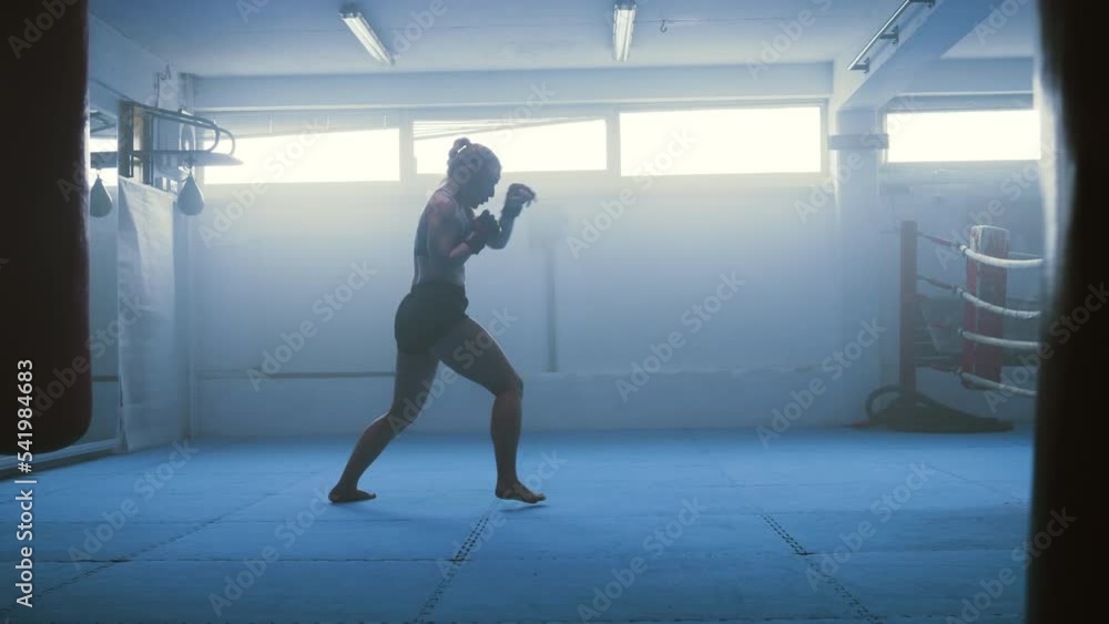 MMA female fighter exercising in gym, training leg strike slow motion ...