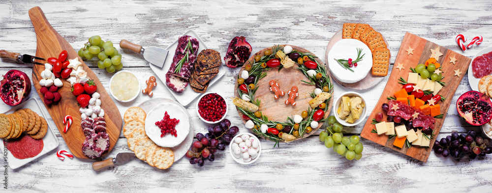 Christmas charcuterie table scene over a white wood banner background ...