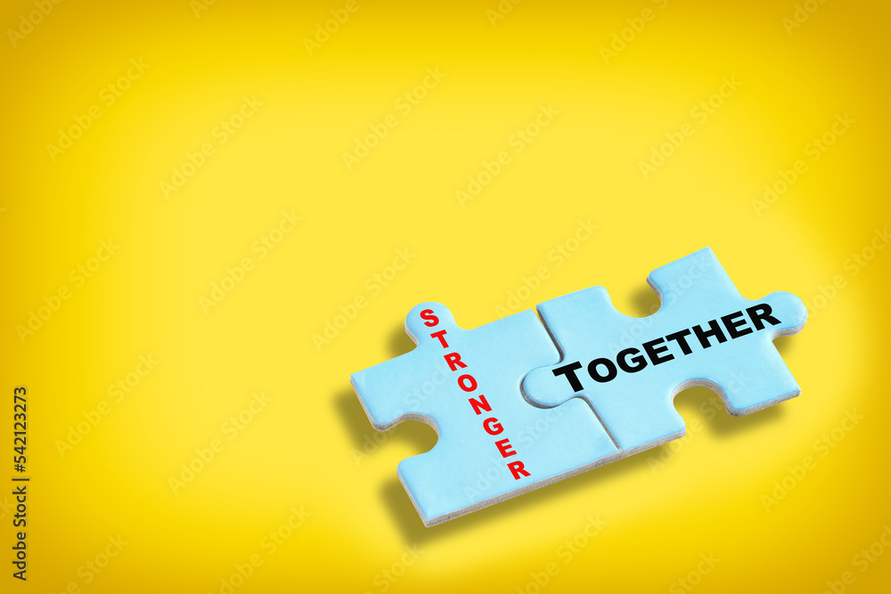 Stronger together on blue puzzle jigsaw with shadow on yellow ...