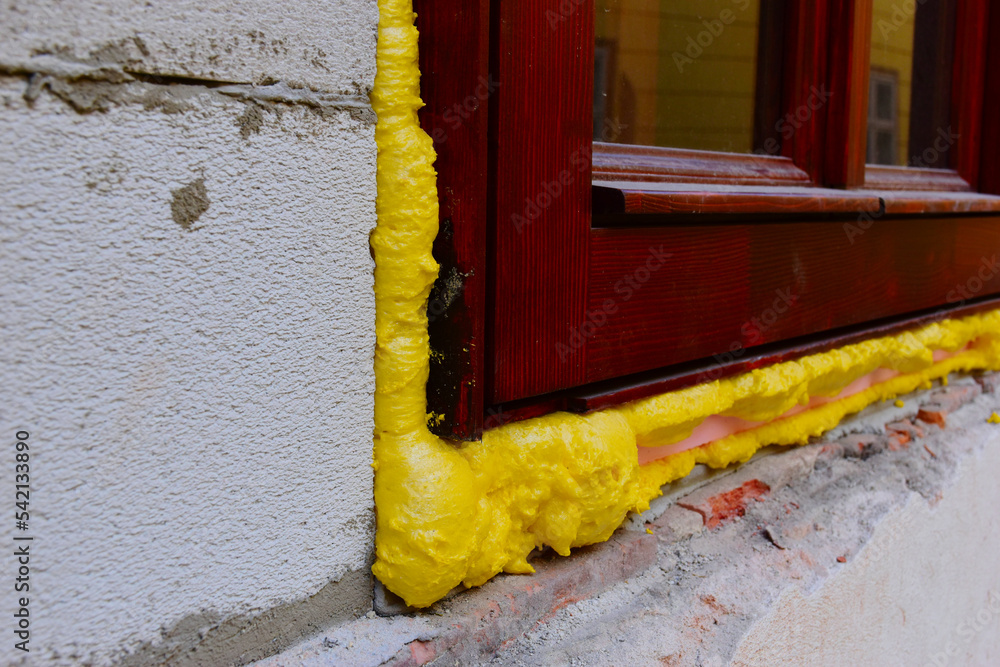 stained wood window frame in masonry wall during construction. yellow ...