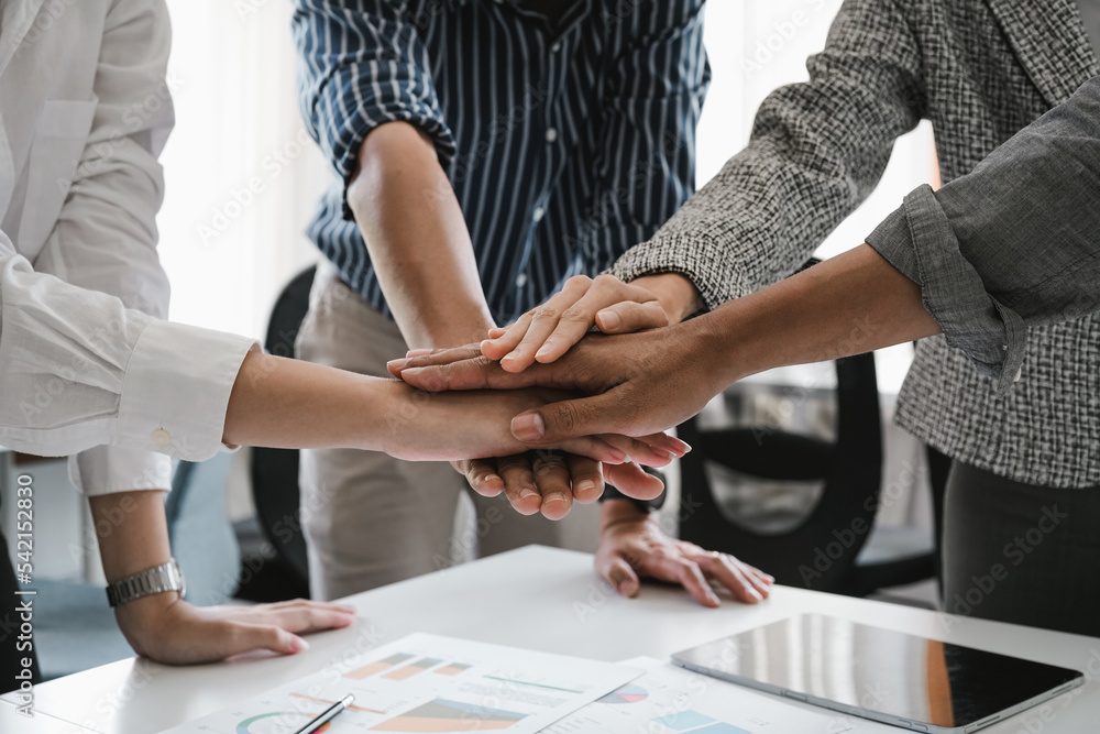 Close up happy diverse business people putting hands together, showing ...