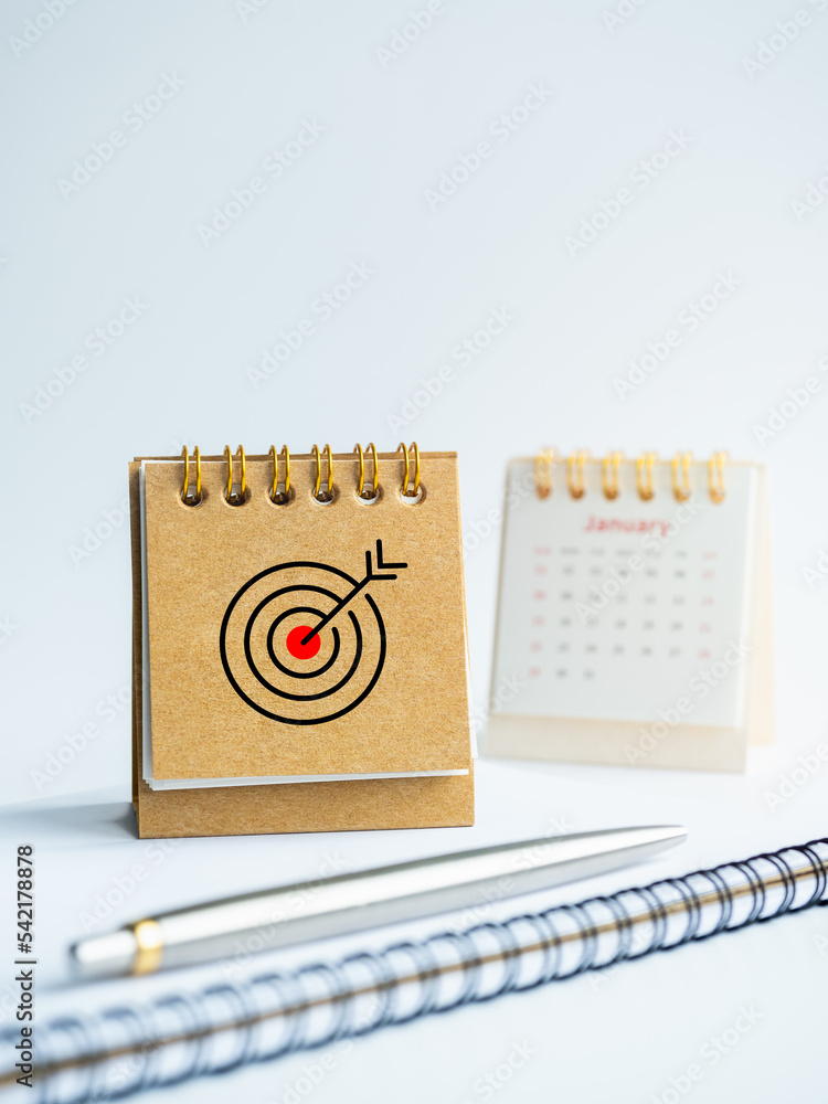Target icon on 2023 year desk calendar cover near spiral notepad and ...