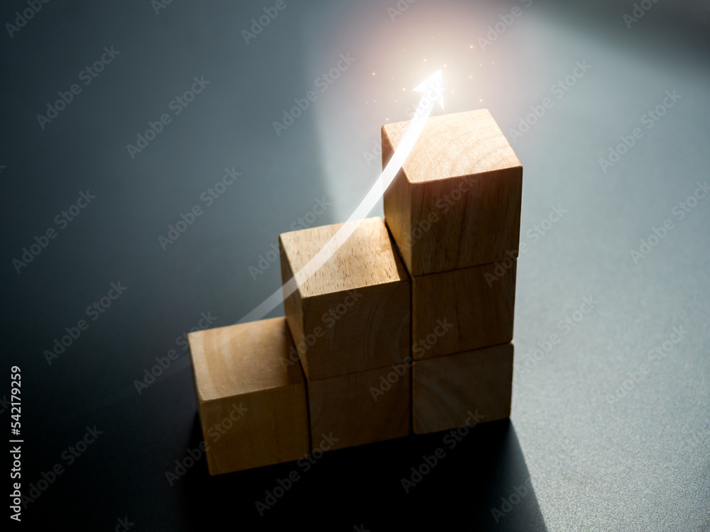 Shining rise up arrow on wooden cube blocks, bar graph chart steps on ...