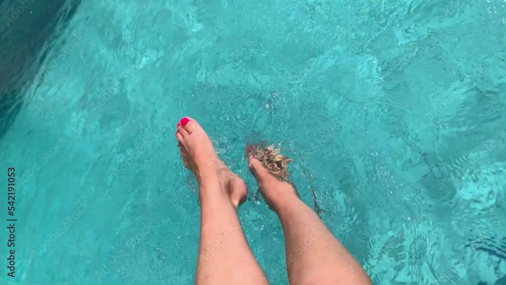 Beautiful sporty slim woman legs relaxing in water swimming pool spa ...