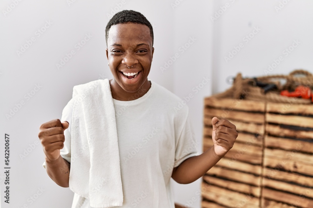 Young african man wearing sportswear and towel screaming proud ...