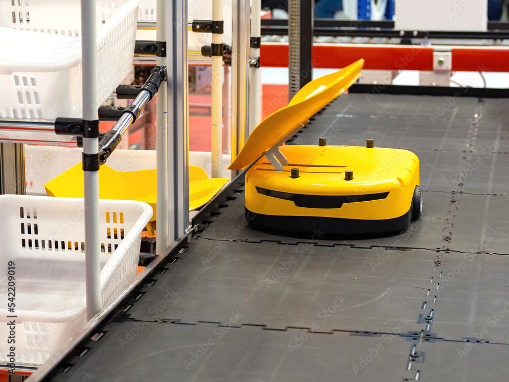 Automatic placement goods in warehouse. Yellow warehouse cart robot ...