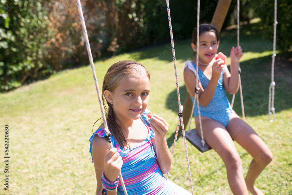 Foto de Portrait of two little girls on swings in yard. Happy Caucasian ...