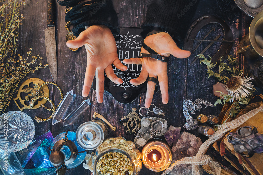 Hands making a magic gesture. Casting spells. Occult altar with ...