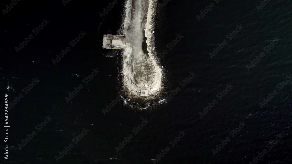 Bird's-eye view of a breakwater with people walking on the fishing pier ...