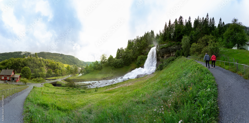 Beautiful nature walk on a cloudy day next to a waterfall in a green ...
