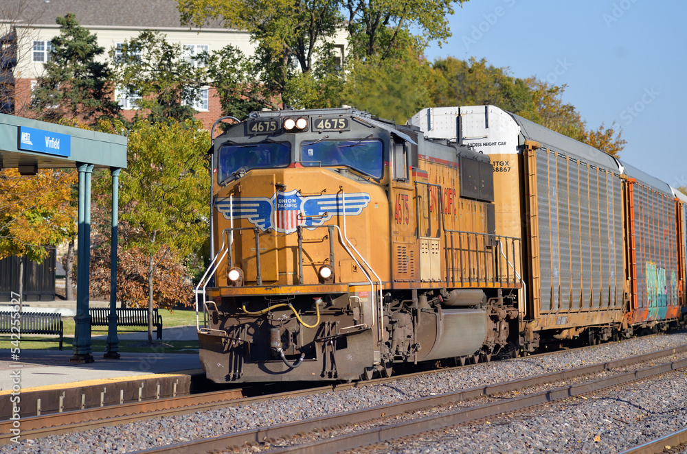 A single locomotive leads a freight train around a curve and through ...