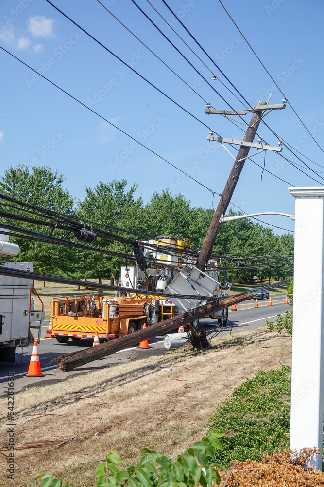 Electric utility repair crew on the scene of a broken wooden utility ...