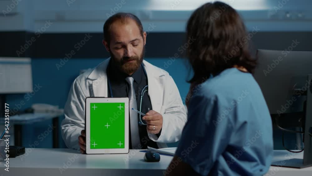 Medic holding digital device pointing at green screen chroma key ...