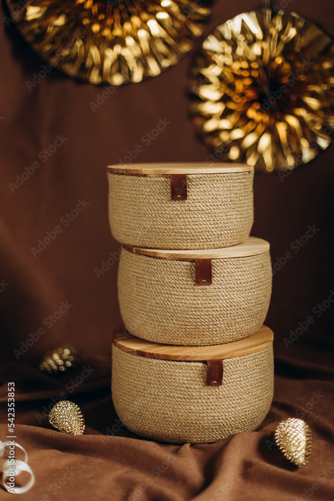 three closed craft baskets made of jute thread on a brown fabric ...