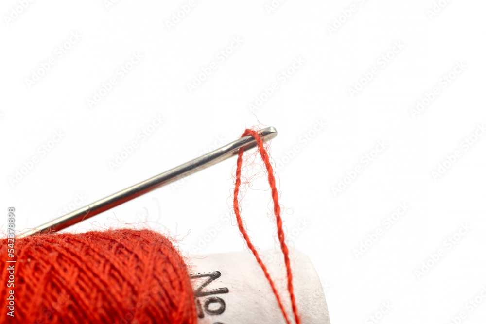 Spool of red thread with a needle isolated on white background. Eye of ...