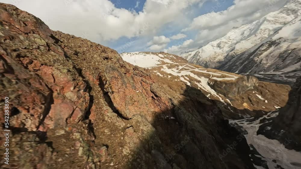 FPV sports drone flying close sheer cliff picturesque natural mountain ...