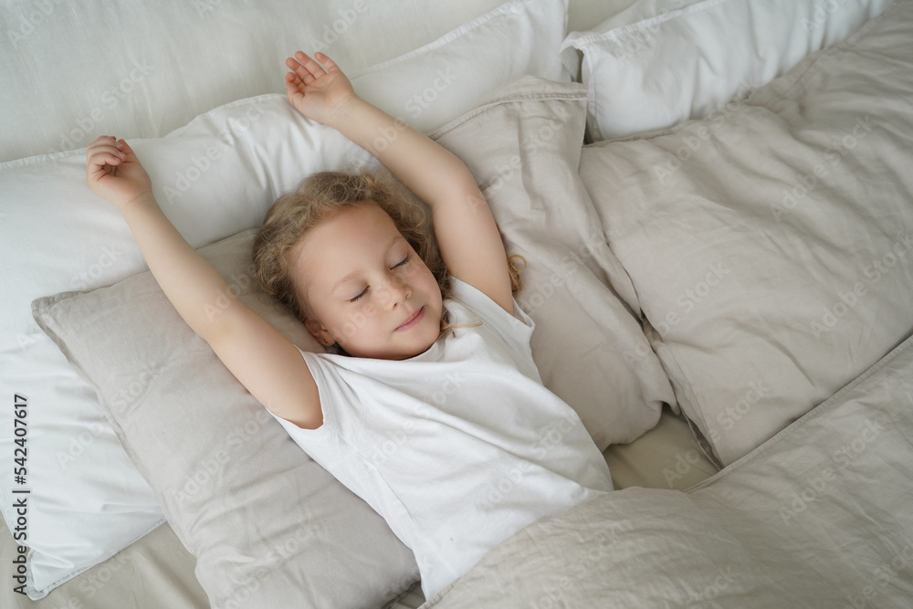 Little child girl sleeping in bed, lying on soft cotton pillow in bedroom. Healthy children's ...