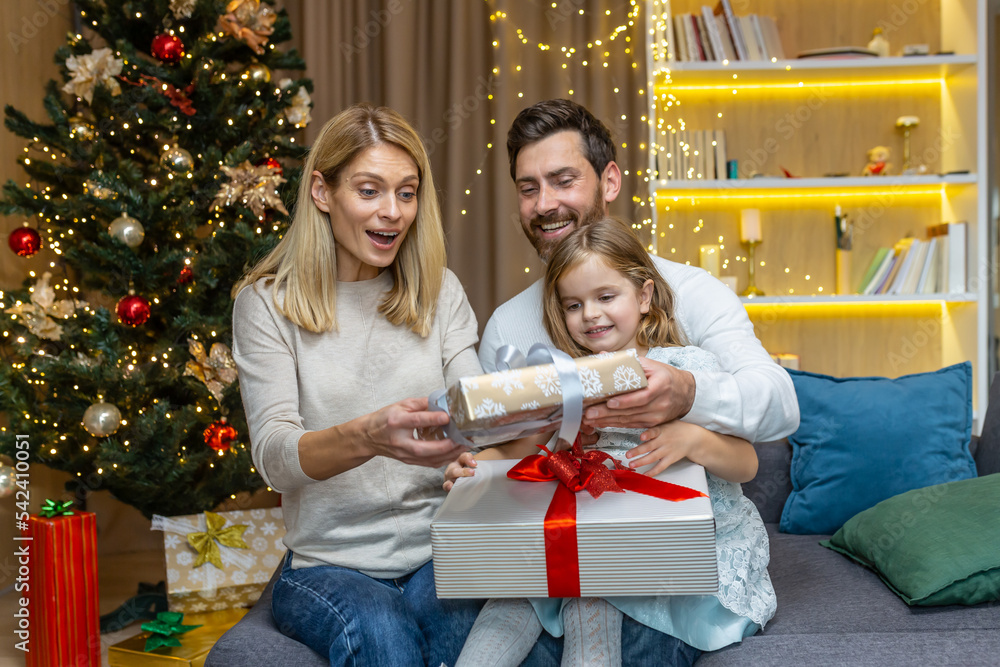 Festive portrait of a young happy family near the Christmas tree at ...