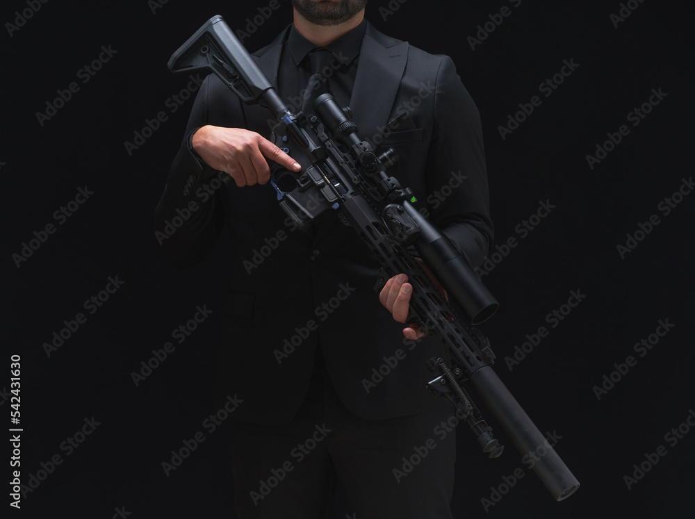 Man in black suit holding assault rifle. Secret service man in black ...