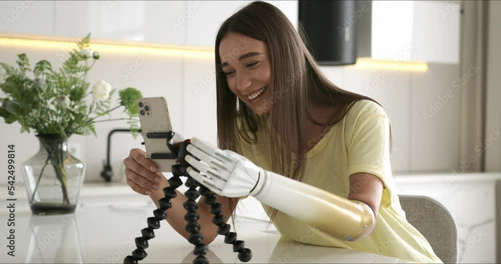 Girl blogger with bionic arm using phone, live streaming social media ...