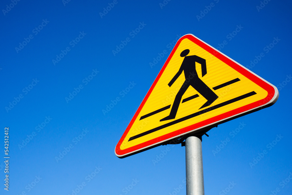 Pedestrian crossing road sign. Blue sky empty copy space. Triangle road ...