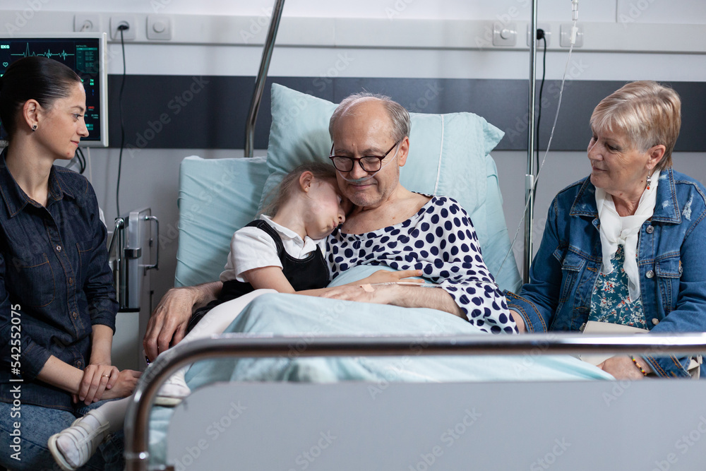 Little girl hugging grandfather at sanatorium room before surgery in ...
