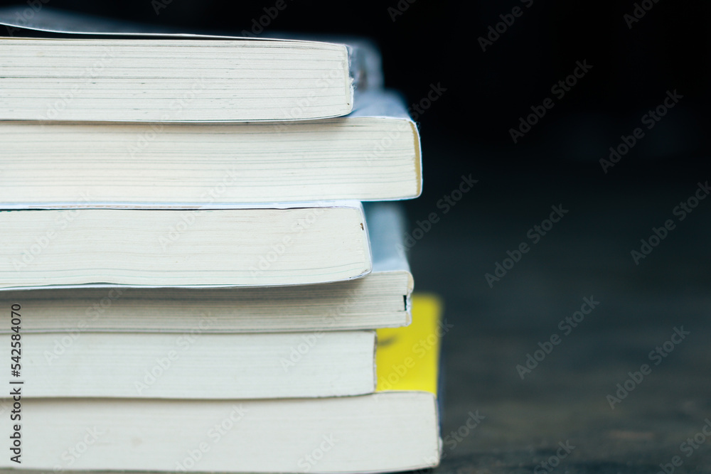 pile of books with side view of white books in library with blur and ...