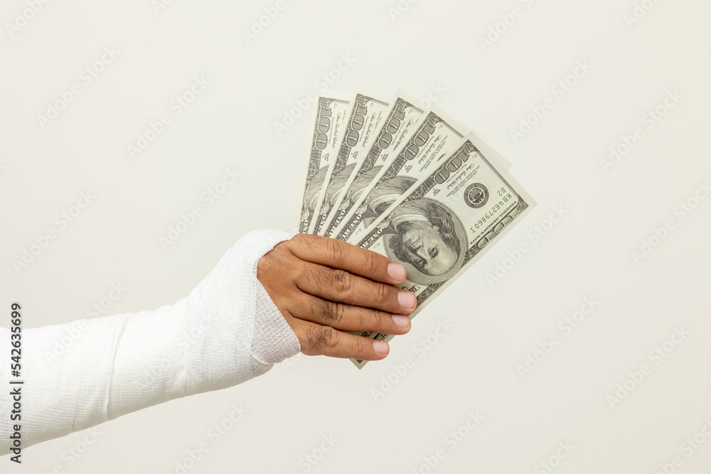 Closeup young man broken arm holding Dollar banknote. Man put on ...