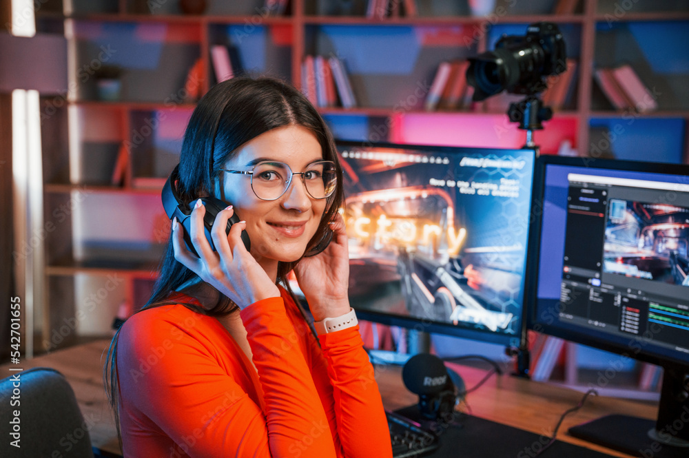 Positive facial expression. Young beautiful game streamer is indoors ...