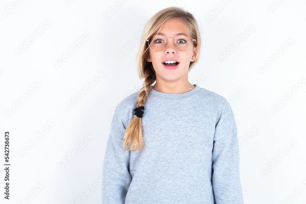 Shocked beautiful caucasian teen girl wearing gray sweater over white ...