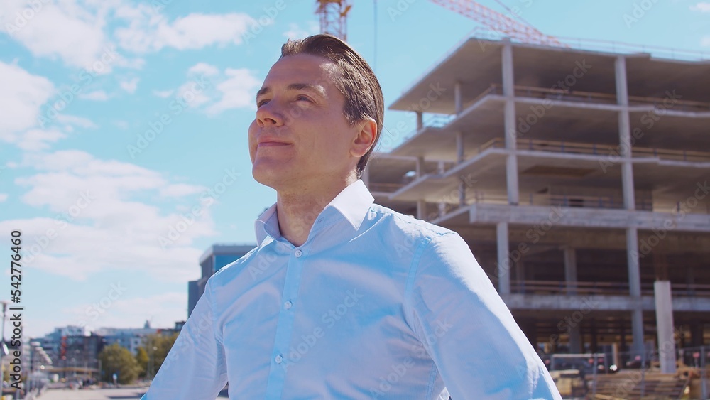 Business person standing in front of construction site. Office building ...