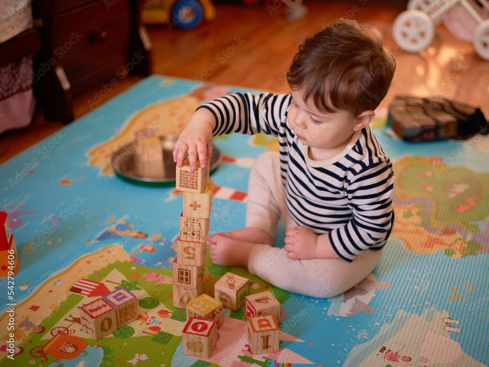 cute baby boy making a tower from wood blocks Stock Photo | Adobe Stock