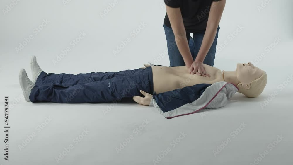 woman doing cpr on a mannequin with clothes on in front of a white ...