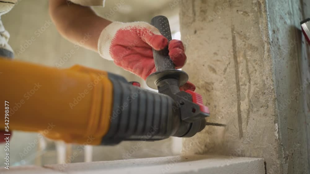 Vidéo Stock The master drills a wall for fixing the future foam block ...