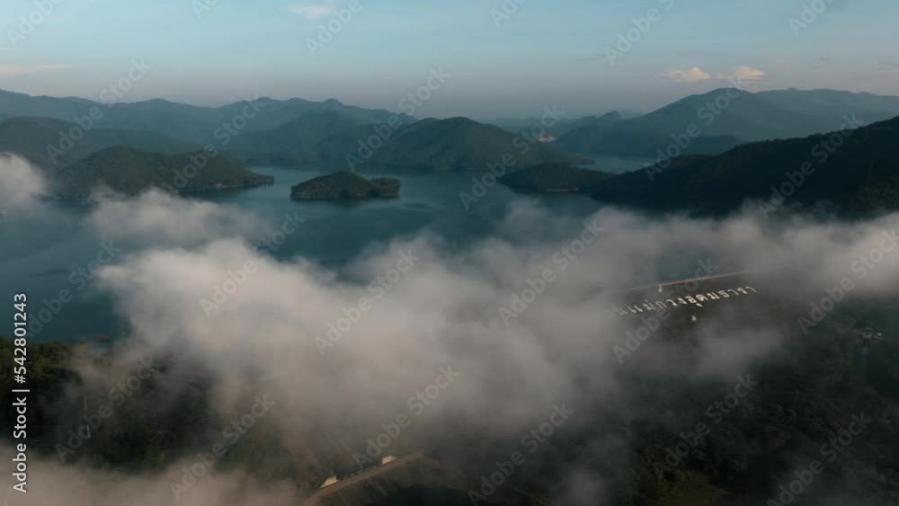 Drone pans just right in top of clouds layer in massive dam in the ...