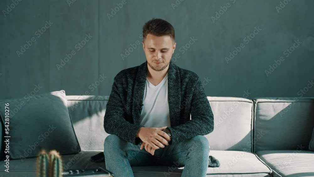 Video „Insecure guy is sitting on sofa and preparing to record video ...