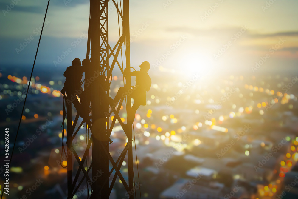 Silhouette workers construction the extension of high-voltage towers on ...