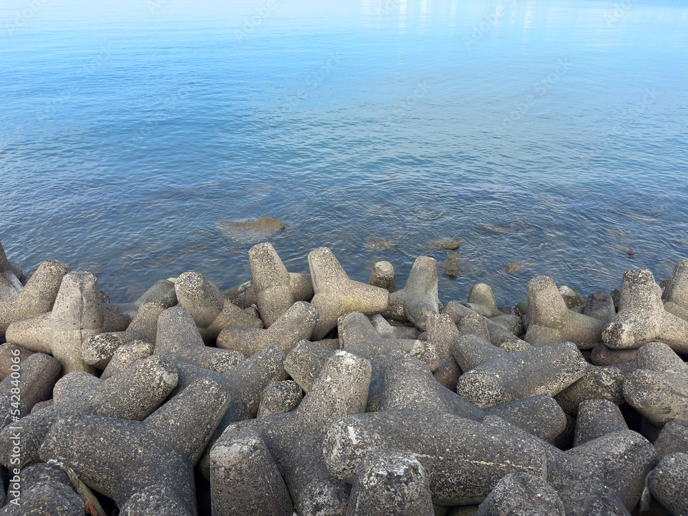 Concrete tetrapods and blue water. Tetrapod breakwaters in sea water ...