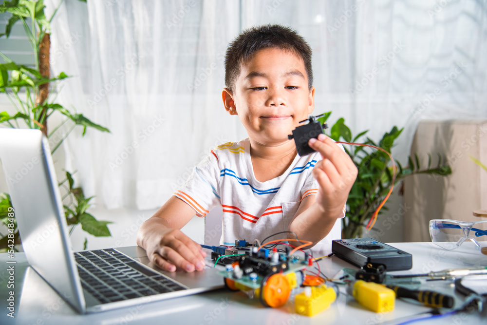 Fotka „Little student child holding stepping motor to assemble car toy ...
